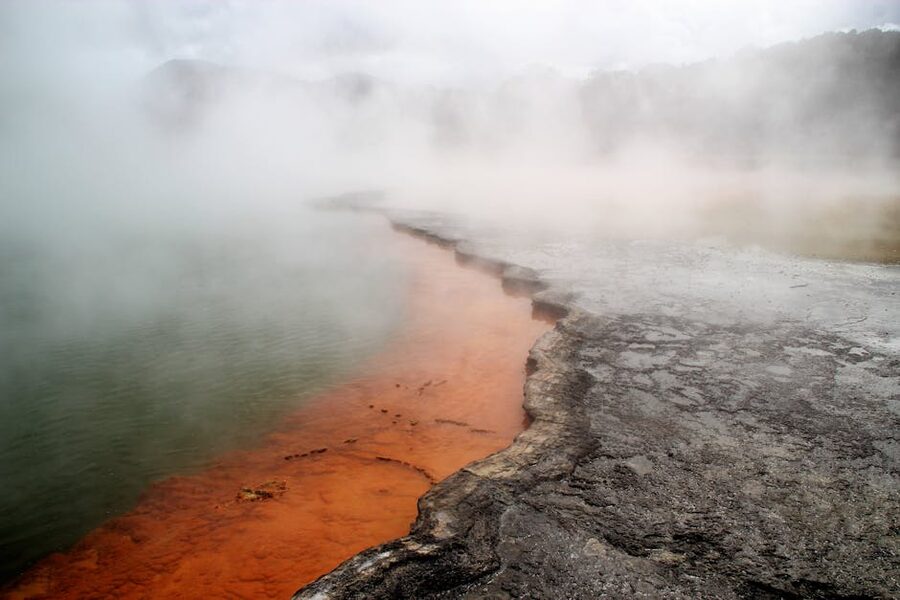 Steaming geothermal spring with mineral colors in Rotorua