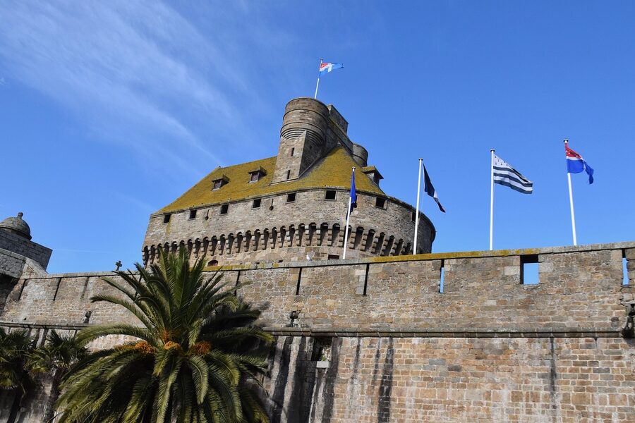 Saint-Malo castle turret with French flags under blue sky