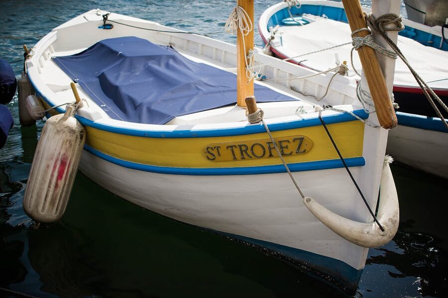 Traditional wooden boat with red and yellow paint moored in Saint-Tropez harbour