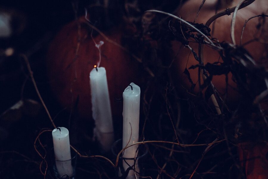 Candle flame in darkness evoking Salem ghost tour mood