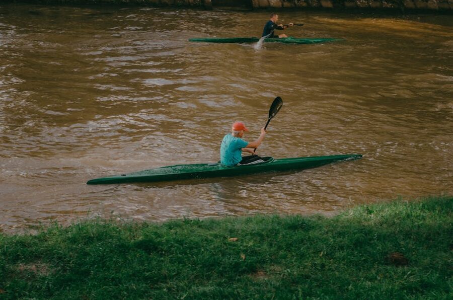 Two people paddling a kayak on a calm river