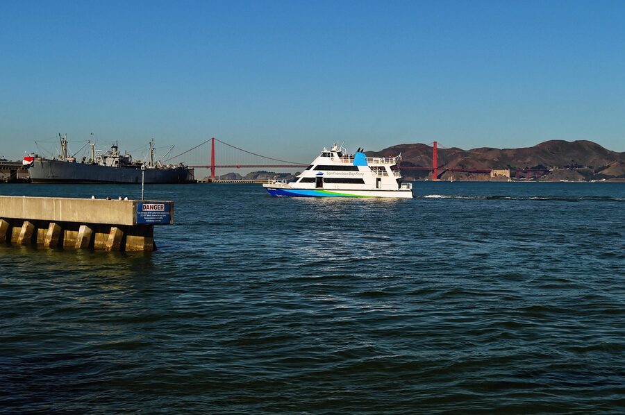 Boats and a ferry on San Francisco Bay with the Golden Gate Bridge in the distance