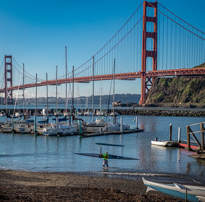 Docked boats beneath the Golden Gate Bridge on a clear day