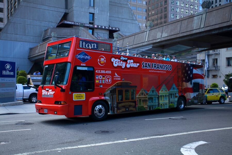 Red open-top city tour bus in a San Francisco urban setting