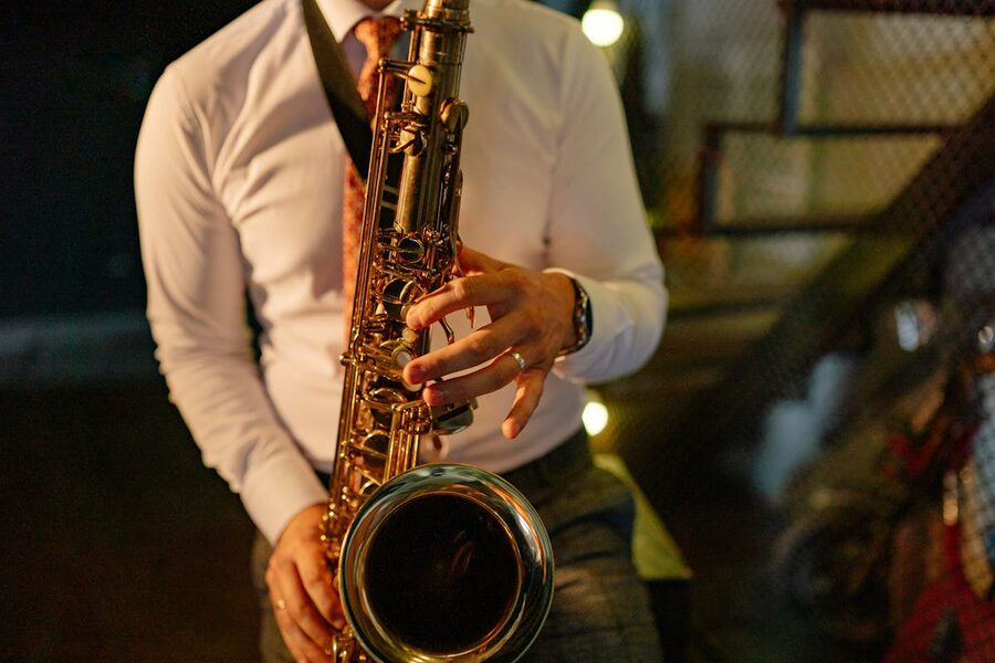 Musician in formal attire plays saxophone indoors