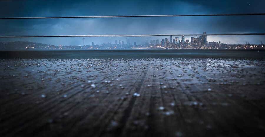 Dramatic Seattle skyline at night under rainy clouds