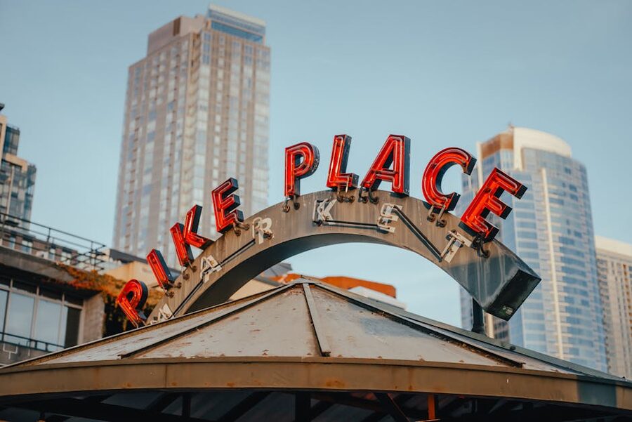 Pike Place Market sign in Seattle with skyscrapers behind