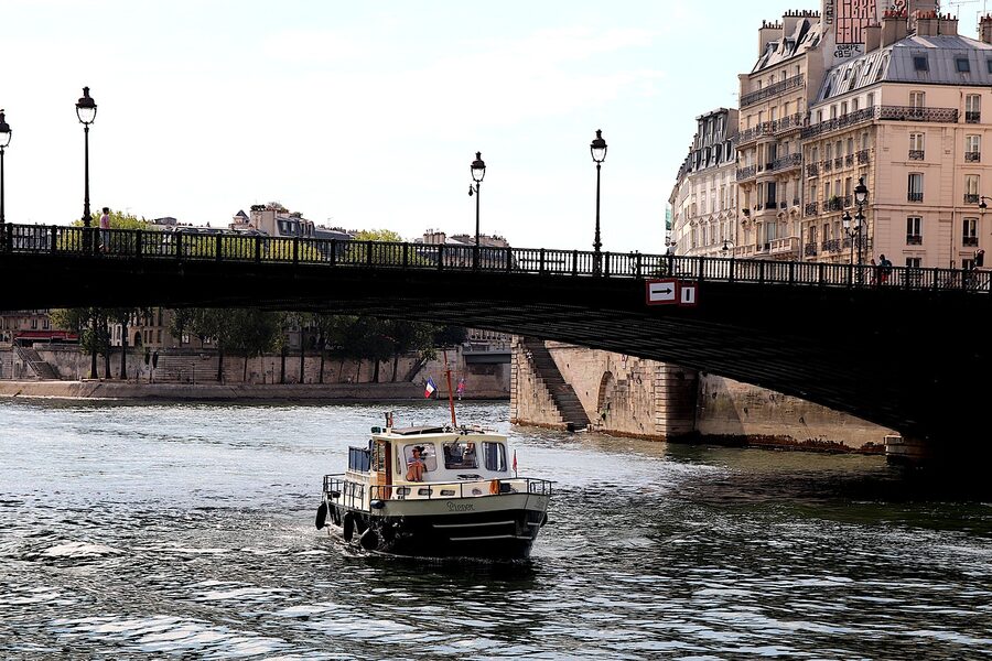 Cruise boat on the Seine passing under a Paris bridge