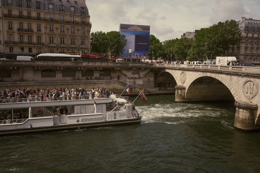 Seine cruise boat passing under a Paris bridge