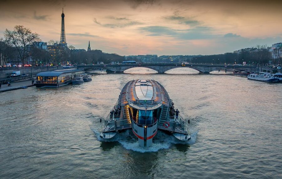 Seine River cruise boat at sunset with Eiffel Tower in Paris