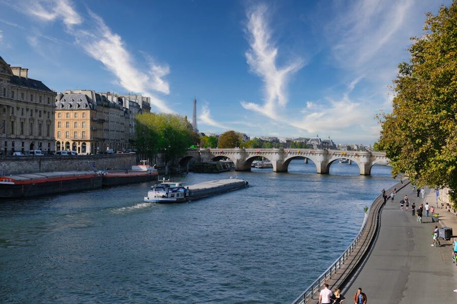 Eiffel Tower over the Seine River with green trees in Paris