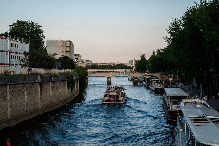Evening Seine cruise boat passing under a Paris stone bridge
