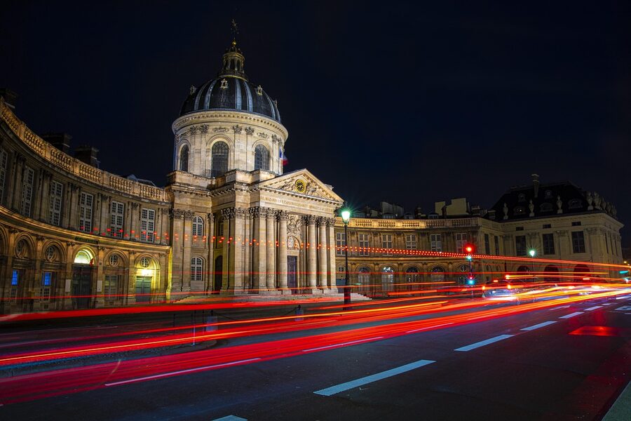 Paris at night with the illuminated Institut de France along the Seine