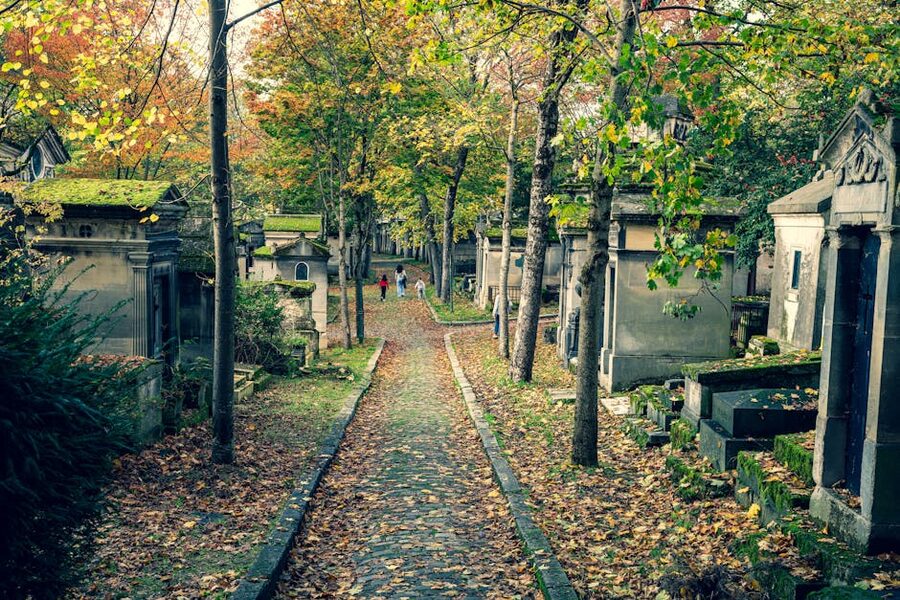 People walking through Père Lachaise on an autumn morning