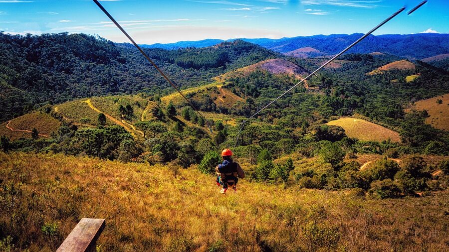 Zipline cable running over a forested mountain hillside