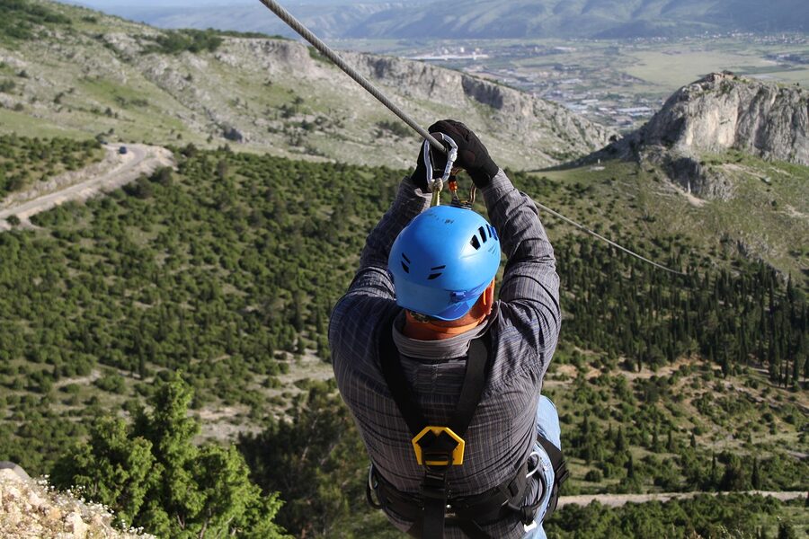 Zipline rider in helmet and harness equipment