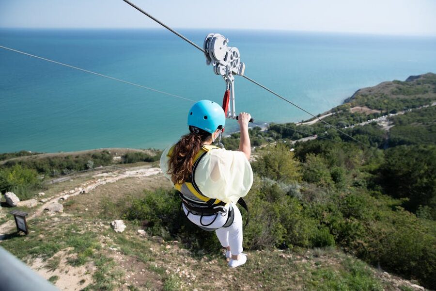 Woman riding a zipline over mountain scenery