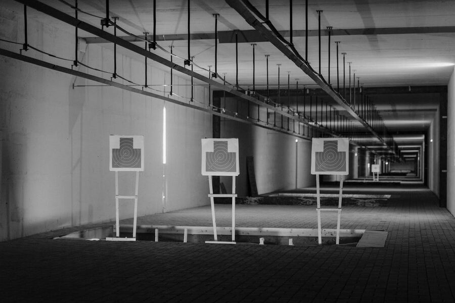Targets lined up at indoor shooting range black and white