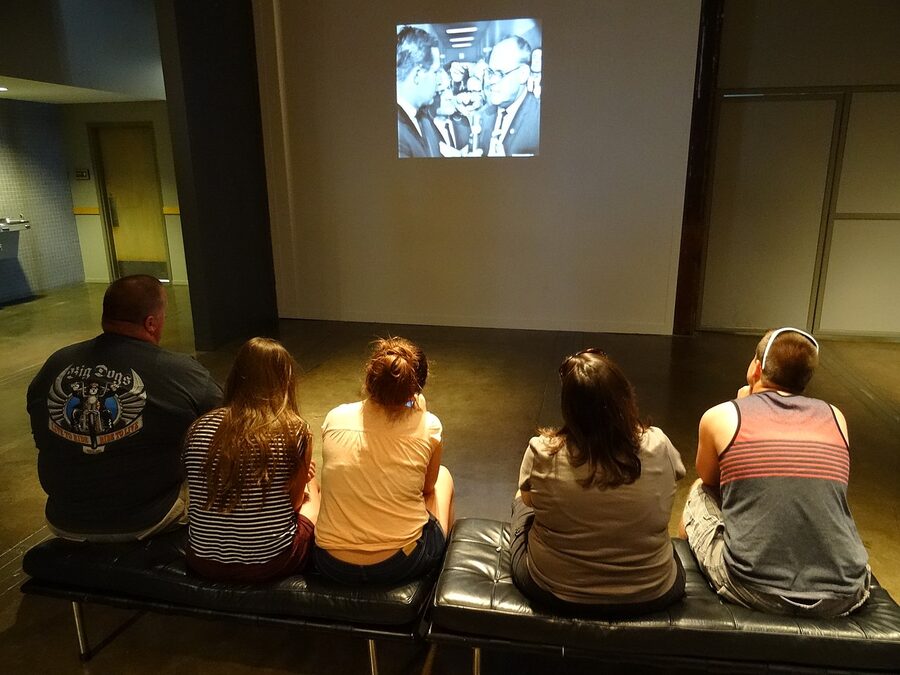 Visitors watching a video exhibit at the Sixth Floor Museum in Dallas