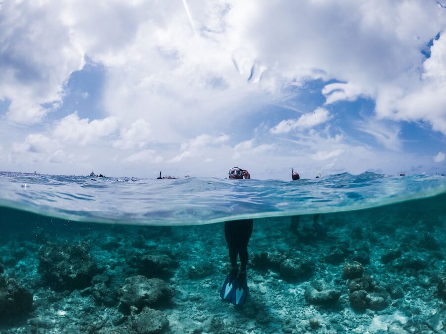 Person in snorkeling mask standing in turquoise tropical sea