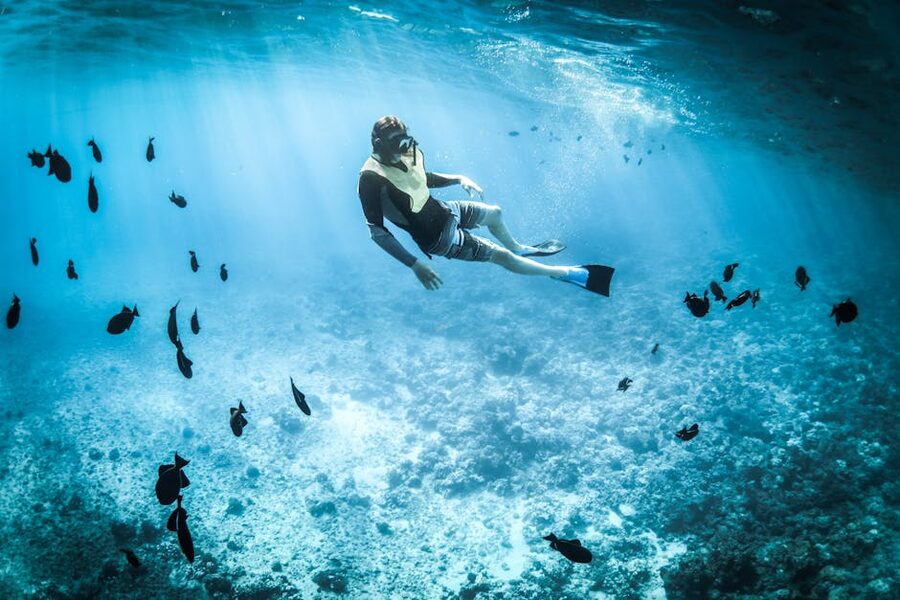 Person snorkeling in tropical turquoise water near coast