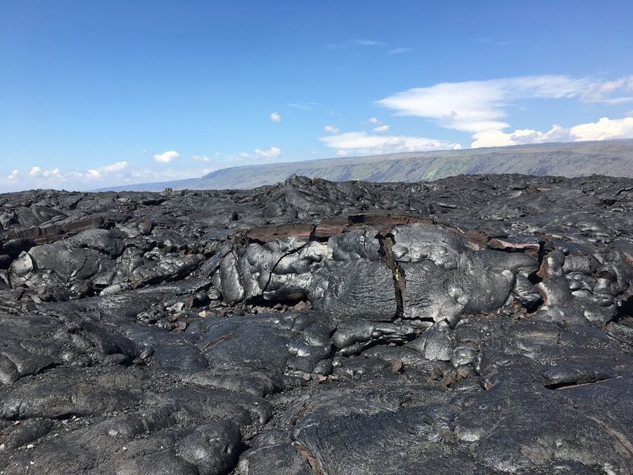 Solidified lava rocks under clear sky at volcano in Hawaii