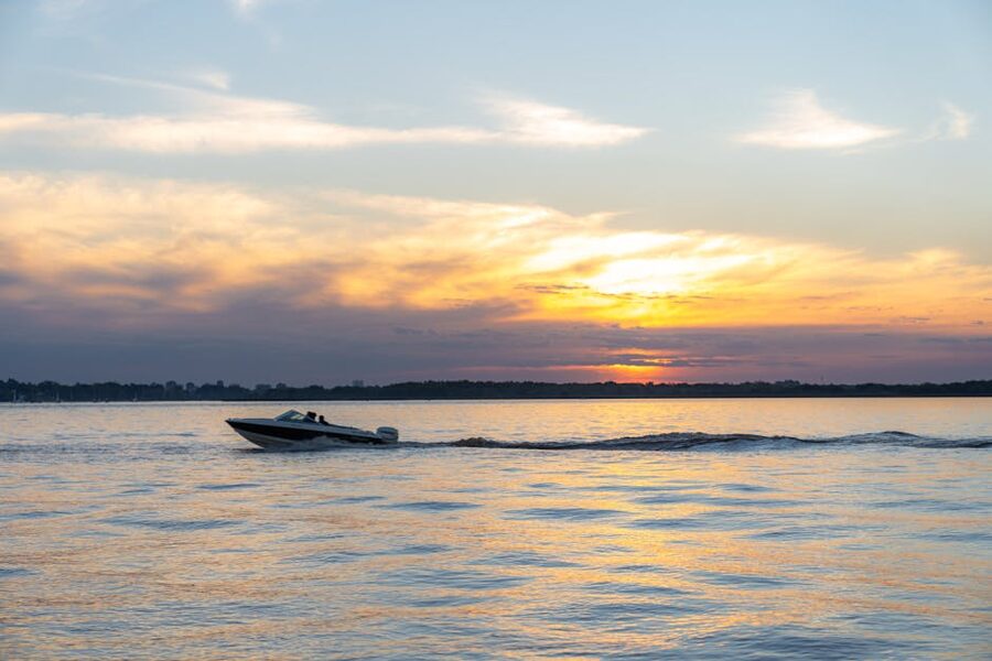 Speedboat gliding over ocean waters at golden hour