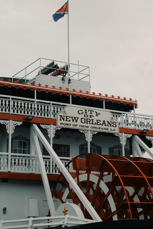 Steamboat with red and white paddle wheel on the river