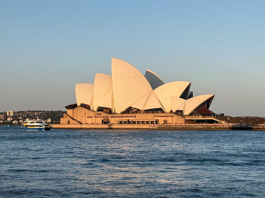 Sydney Opera House at sunset with a ferry crossing the harbour