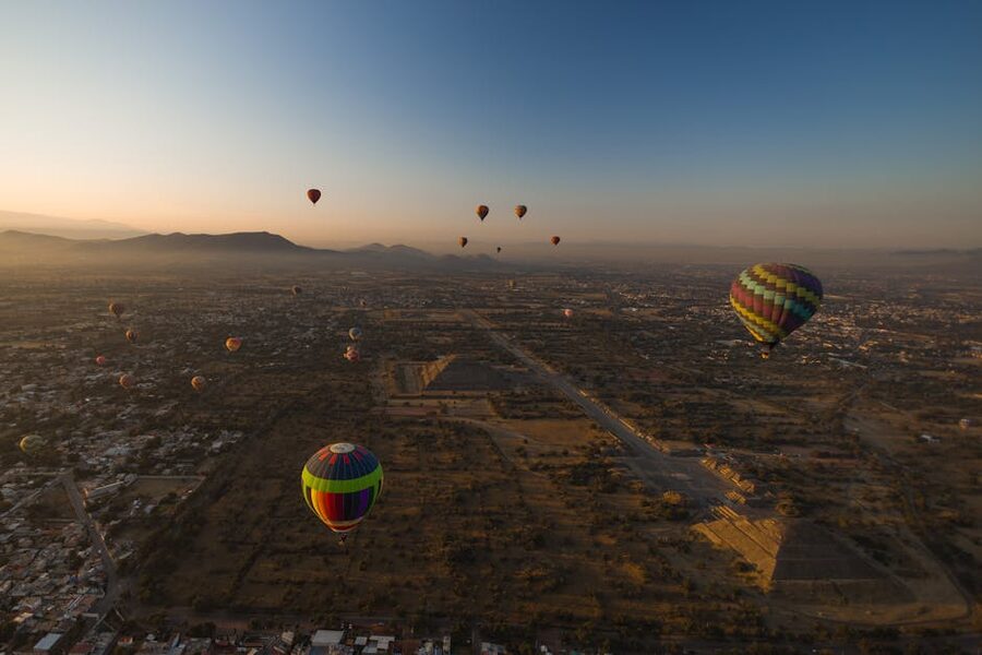 Aerial view of colorful hot air balloons flying over Teotihuacan at sunrise