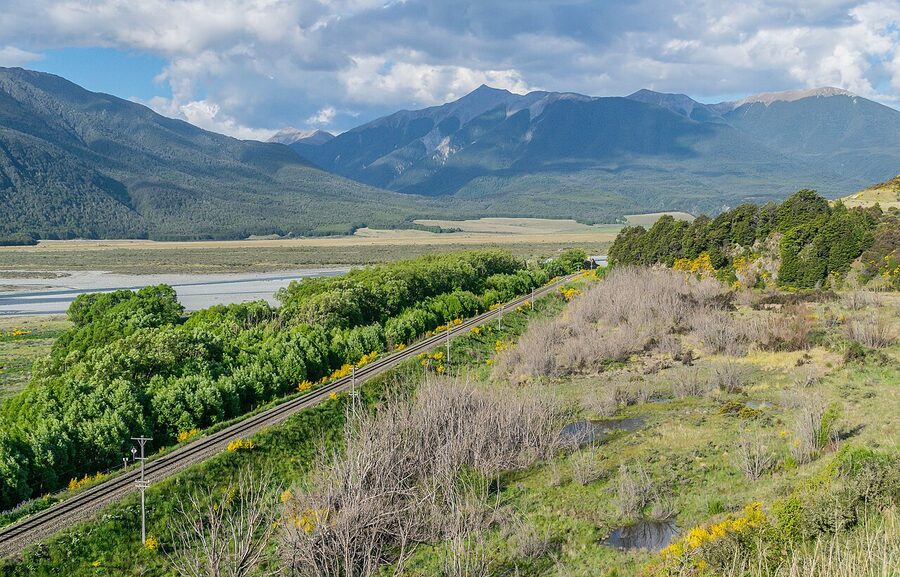 TranzAlpine train in the Waimakariri River valley with snow-capped Southern Alps