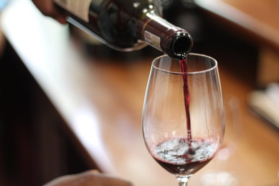 Red wine being poured into a clear wine glass