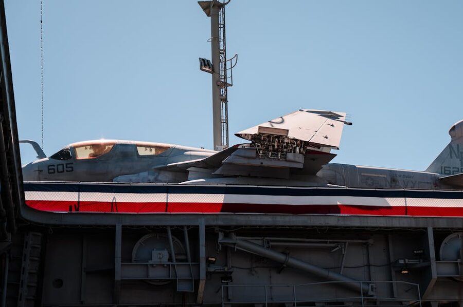 Gray military aircraft on display at the USS Midway under clear blue sky