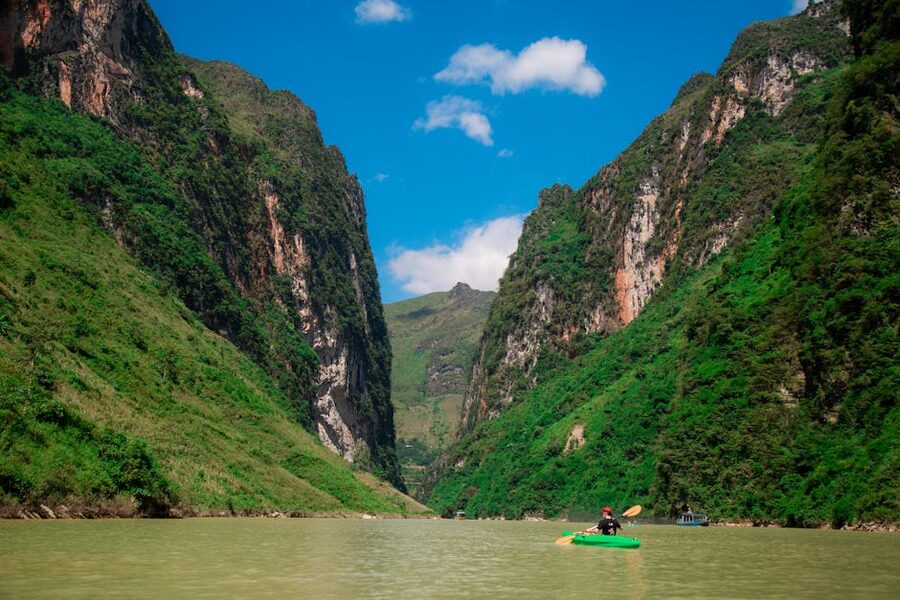 Kayak on calm desert river with canyon walls rising on both sides