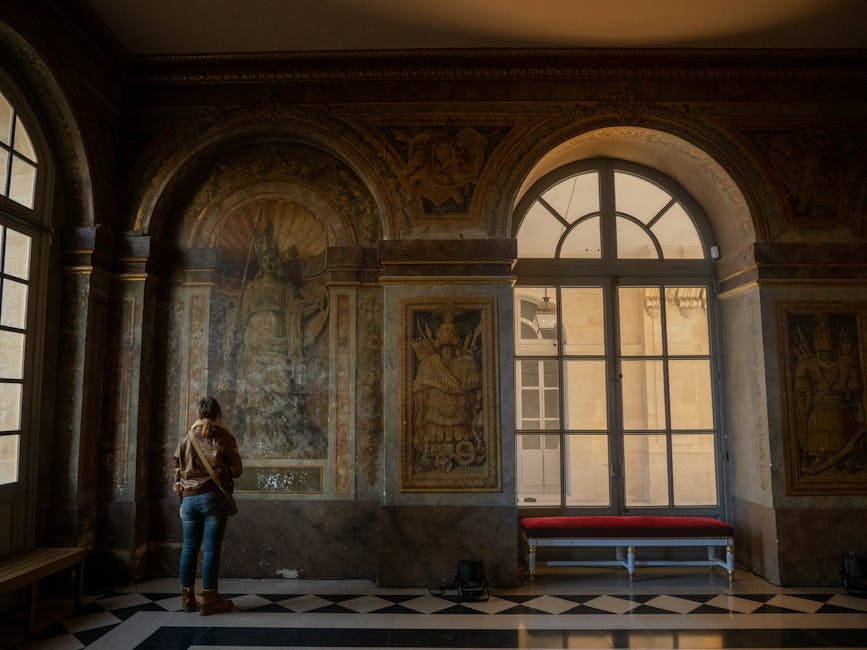 A visitor admires frescoes in the interior of Versailles Palace