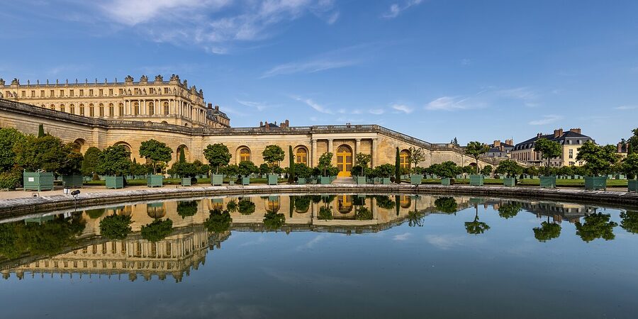 Orangerie garden and Palace of Versailles reflected in water