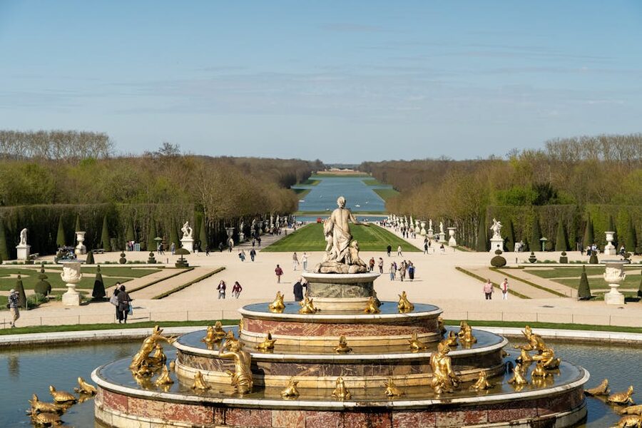 Royal gardens of Versailles with grand fountain and golden statues