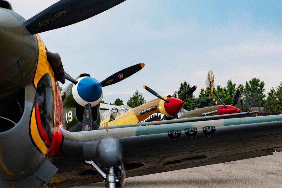 Close-up view of vintage fighter planes with colorful propellers on display