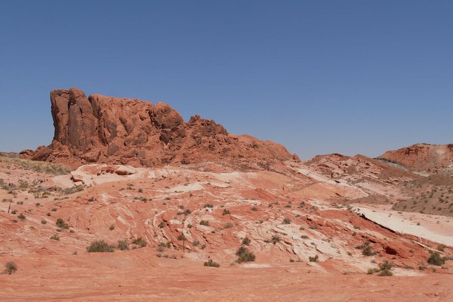 Red rock formations in desert landscape under clear blue sky