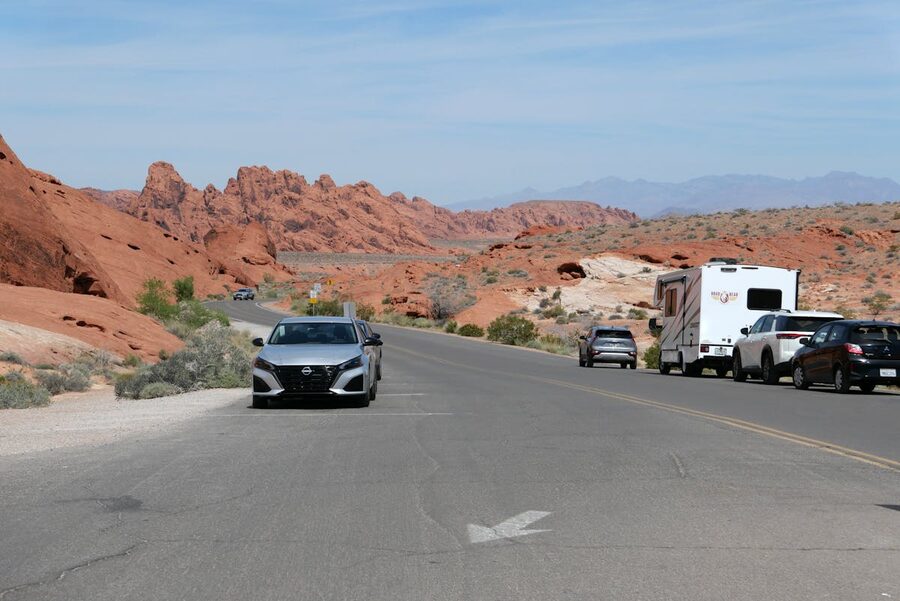 Cars traveling through red rock landscape at Valley of Fire State Park