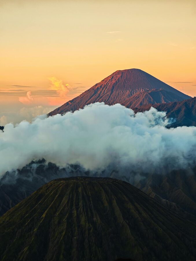 Volcano summit above misty clouds at sunrise