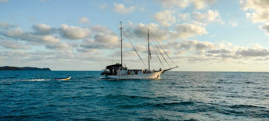 Sailboat cruising calm Whitsundays water Australia