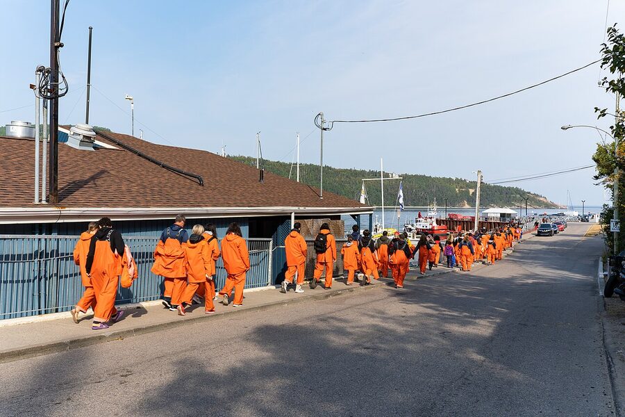 Whale watching tourists in cold weather gear on boat Tadoussac