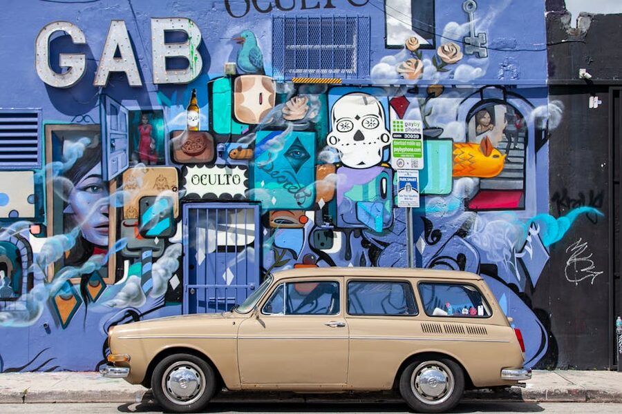 Vintage car parked against a Wynwood street art mural in Miami
