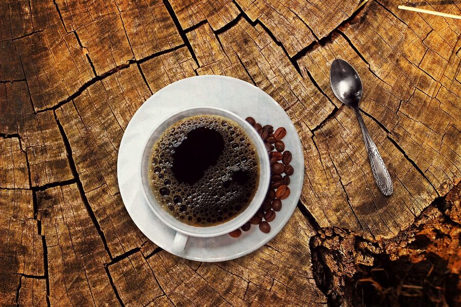 Coffee cup with coffee beans on wooden table cafe con leche