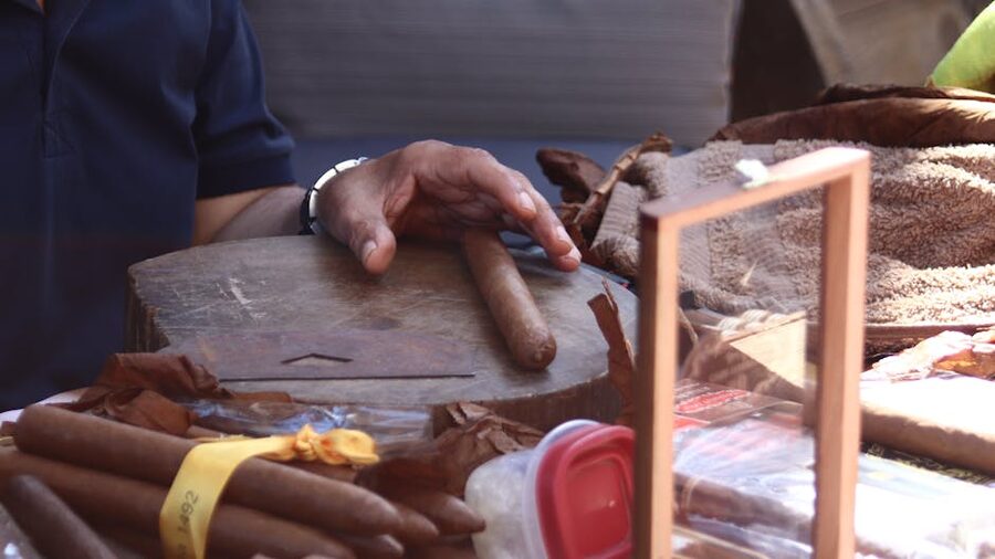 Hand rolling a cigar at a wooden table detailed craft