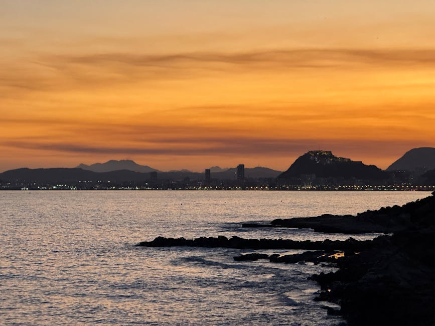 Sunset over Alicante coastline with city in soft light