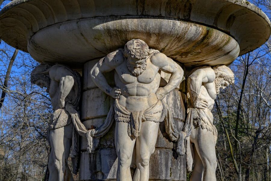 Classical stone fountain with sculpted figures in Aranjuez