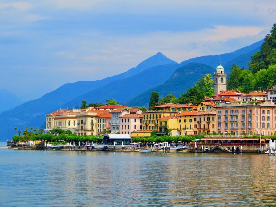 Bellagio port with blue sky and mountain reflections on Lake Como