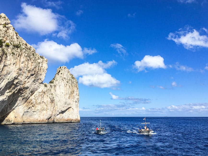 Boats navigating clear blue waters near Capri cliffs